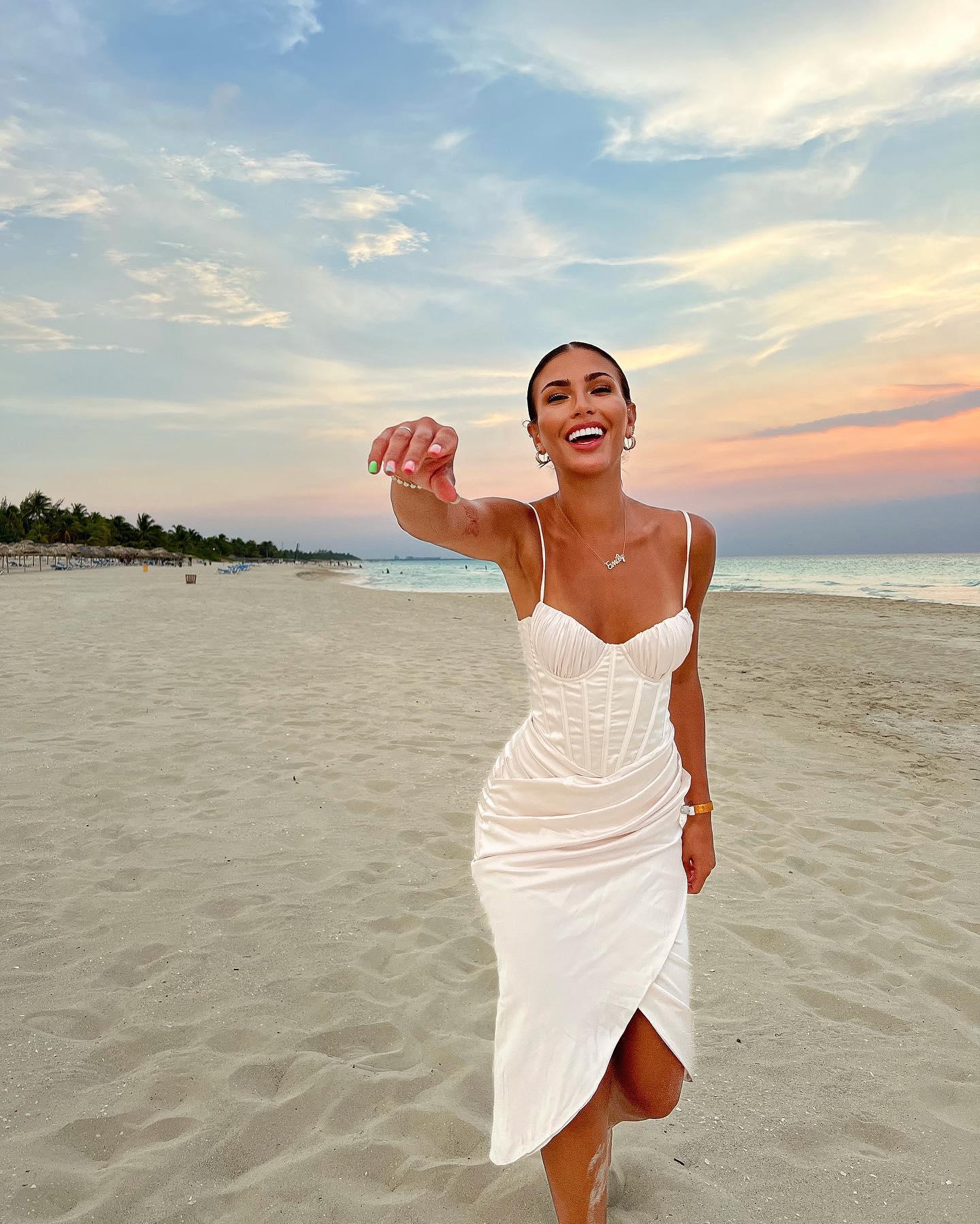 Emily Faye Miller Hits The Beach In A Tight-Fitting White Dress