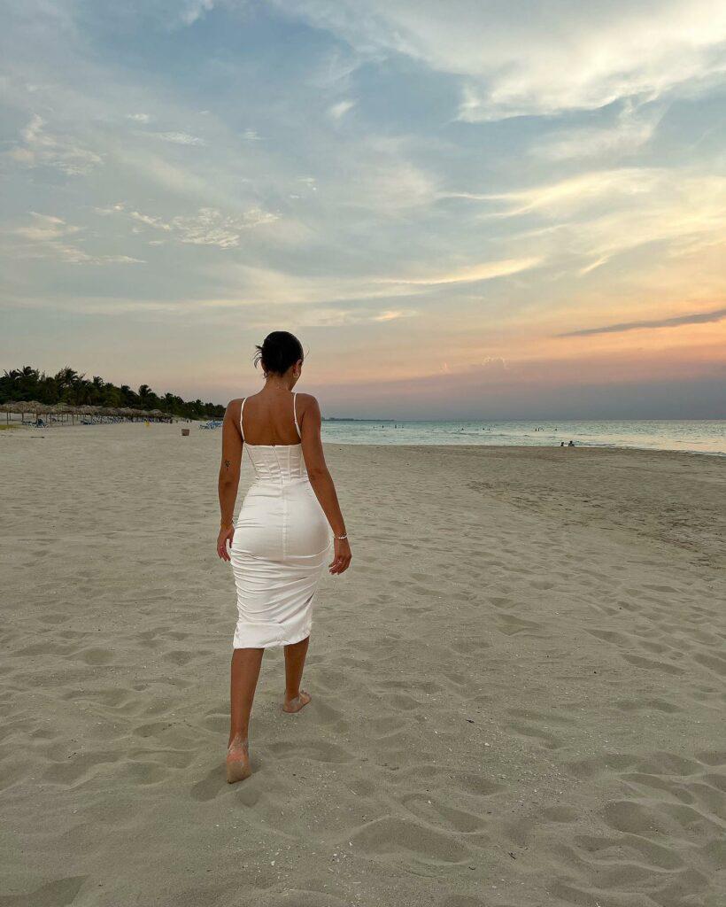 Emily Faye Miller Hits The Beach In A Tight-Fitting White Dress