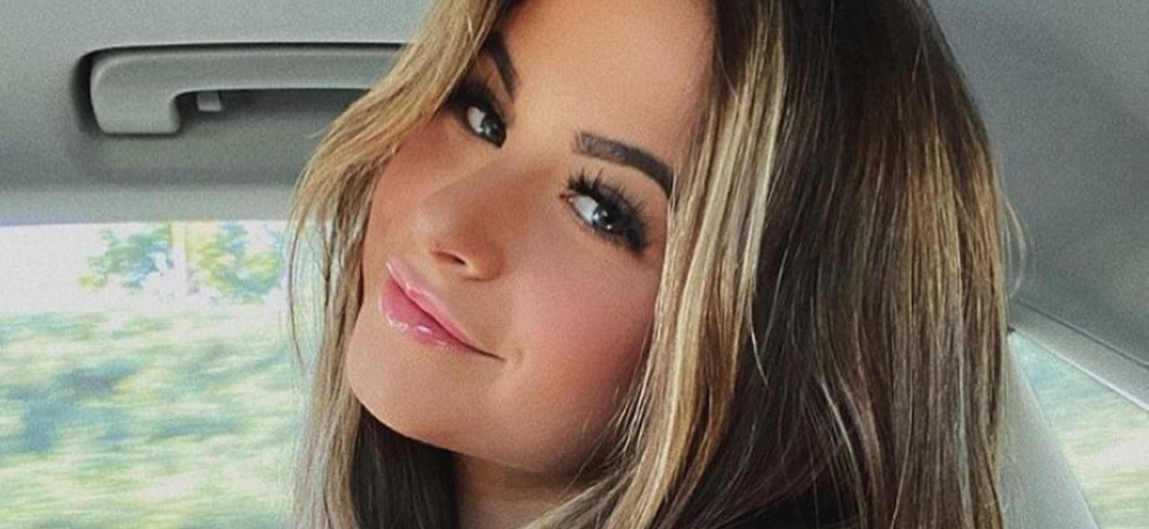 Emily Elizabeth Sits On Beach Sand In Her Cheeky Bikini