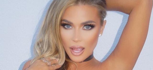 Carmen Electra Leans Over A Staircase In A G-String And Heels