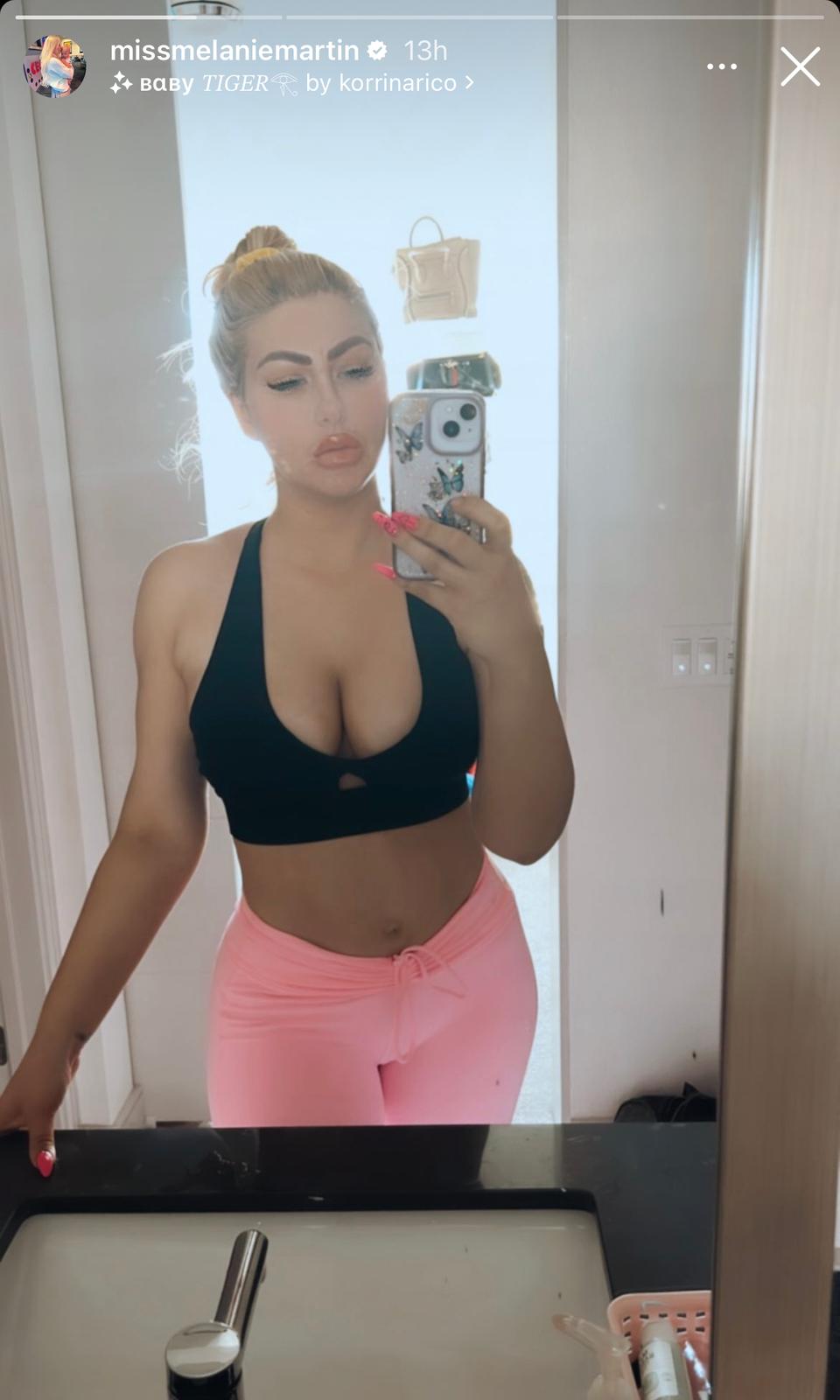 Melanie Martin Puts Up Busty Display In Black Plunging Sport Bra